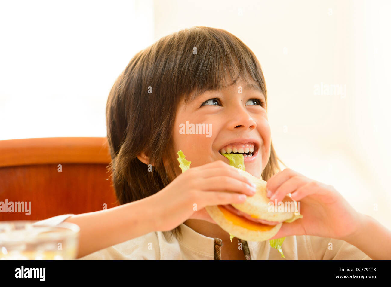 Young boy eating in the kitchen Stock Photo - Alamy