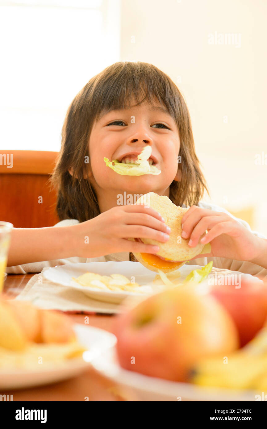 Young boy eating in the kitchen Stock Photo - Alamy