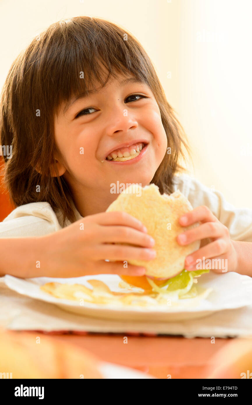 Young boy eating in the kitchen Stock Photo - Alamy