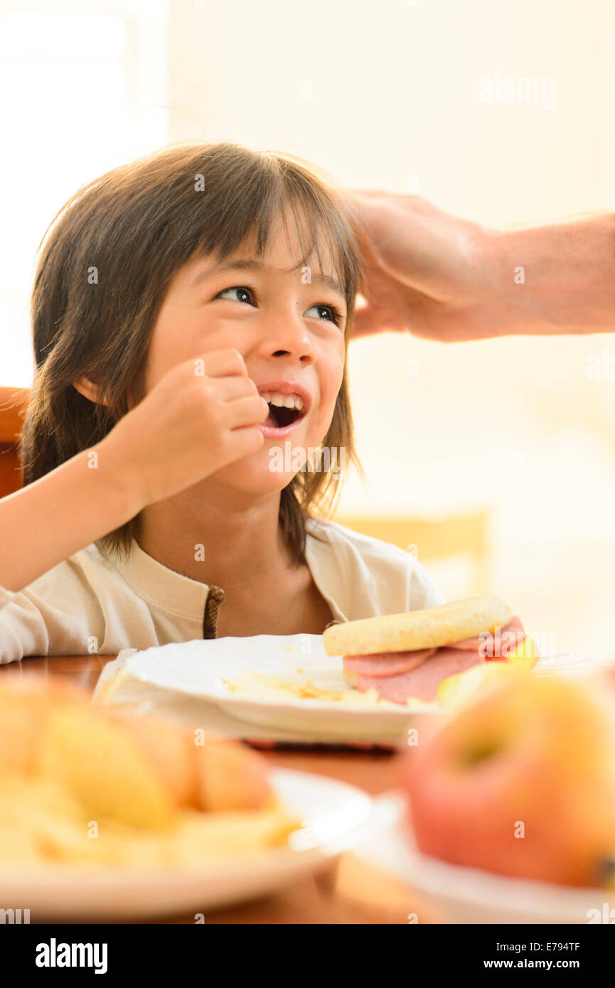 Young boy eating in the kitchen Stock Photo - Alamy