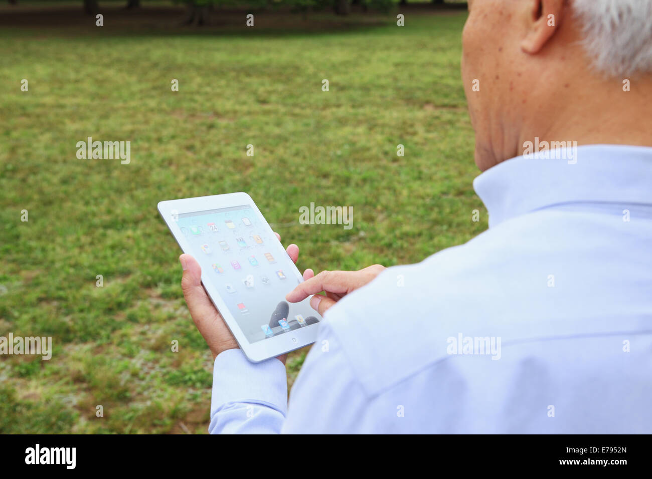 Senior adult Japanese man with tablet in a park Stock Photo - Alamy