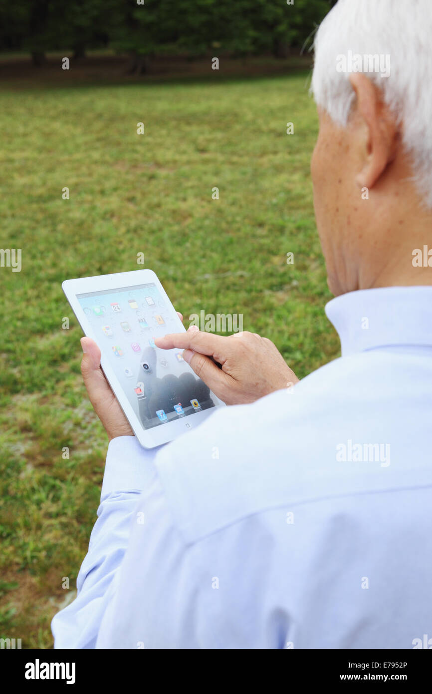 Senior adult Japanese man with tablet in a park Stock Photo - Alamy