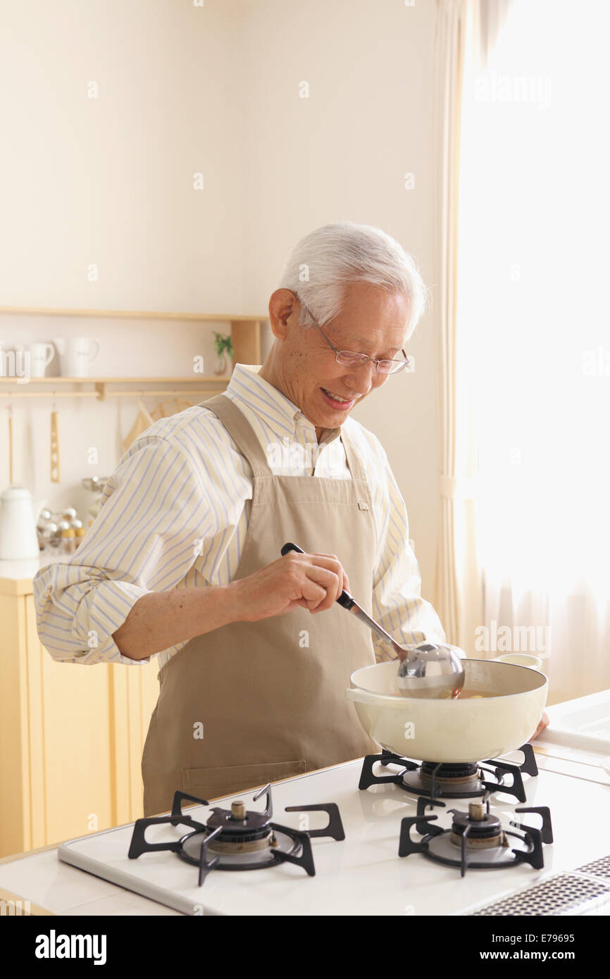 Senior adult Japanese man cooking Stock Photo - Alamy