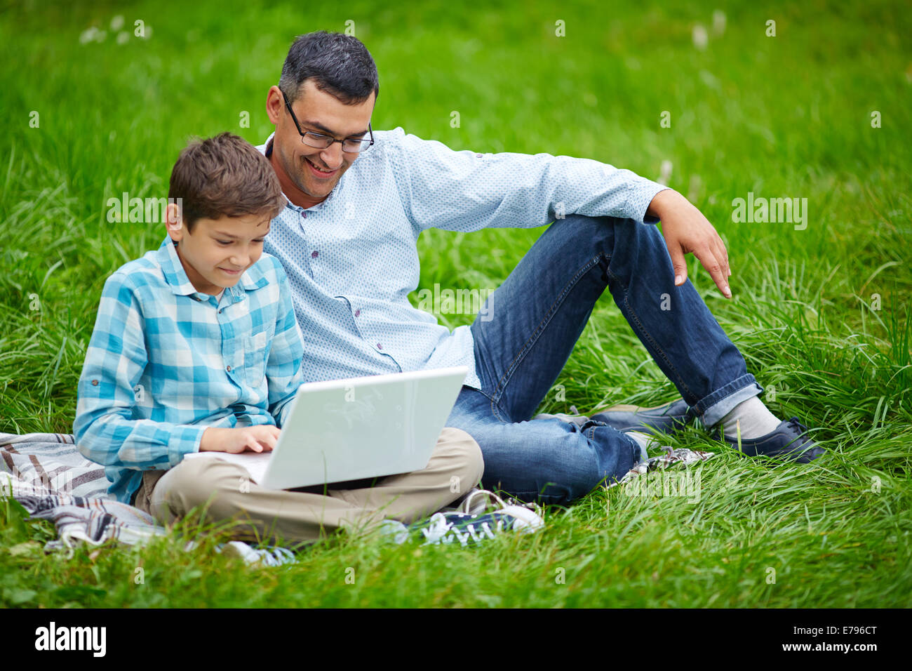 Young man and his son networking outdoors Stock Photo - Alamy