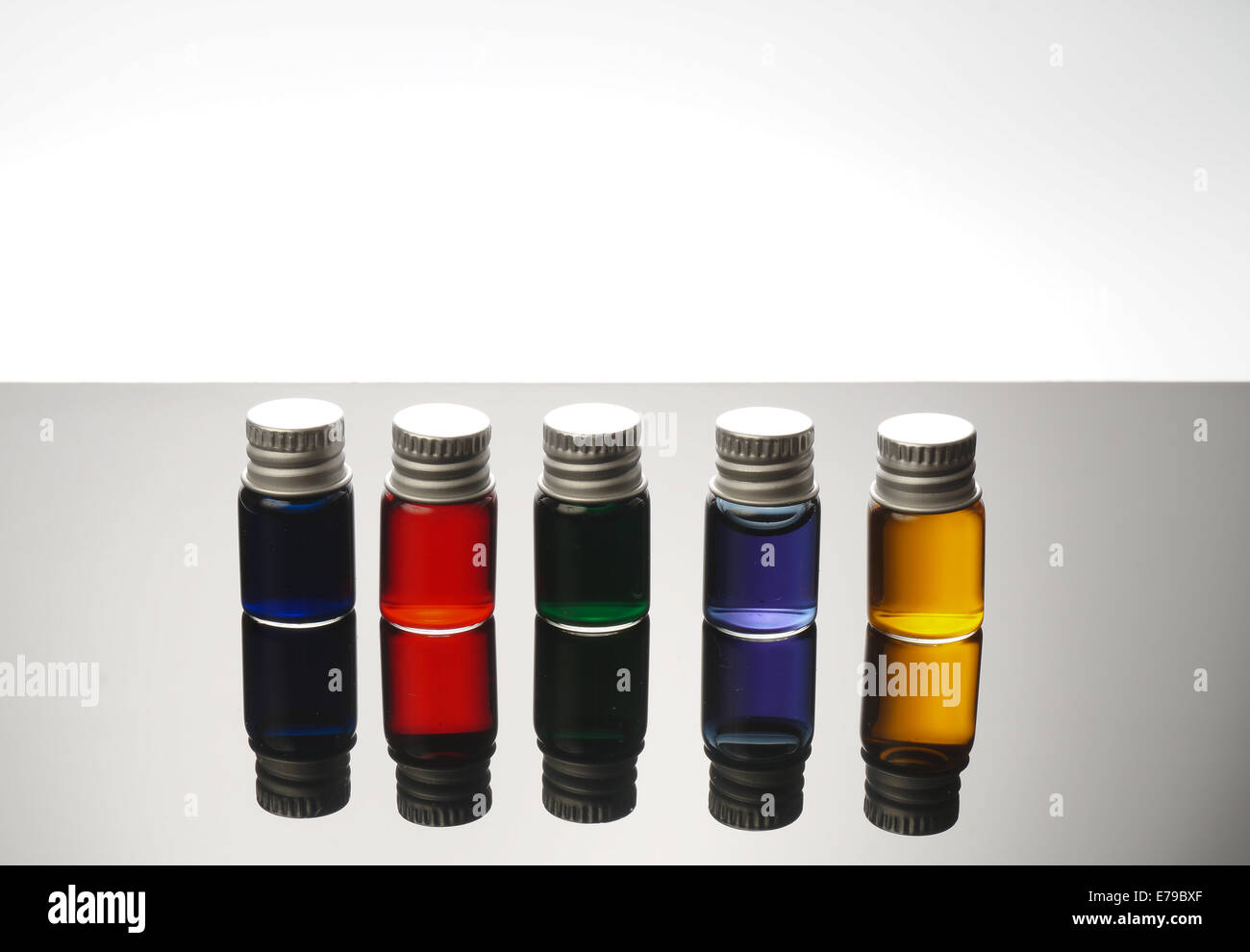 Five Colorful vials isolated on black background Stock Photo - Alamy