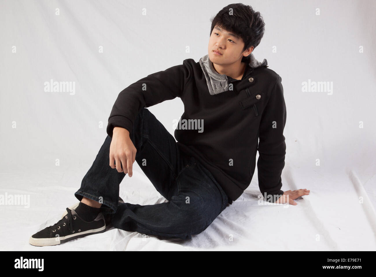 Asian man sitting on the floor and looking thoughtfully Stock Photo - Alamy
