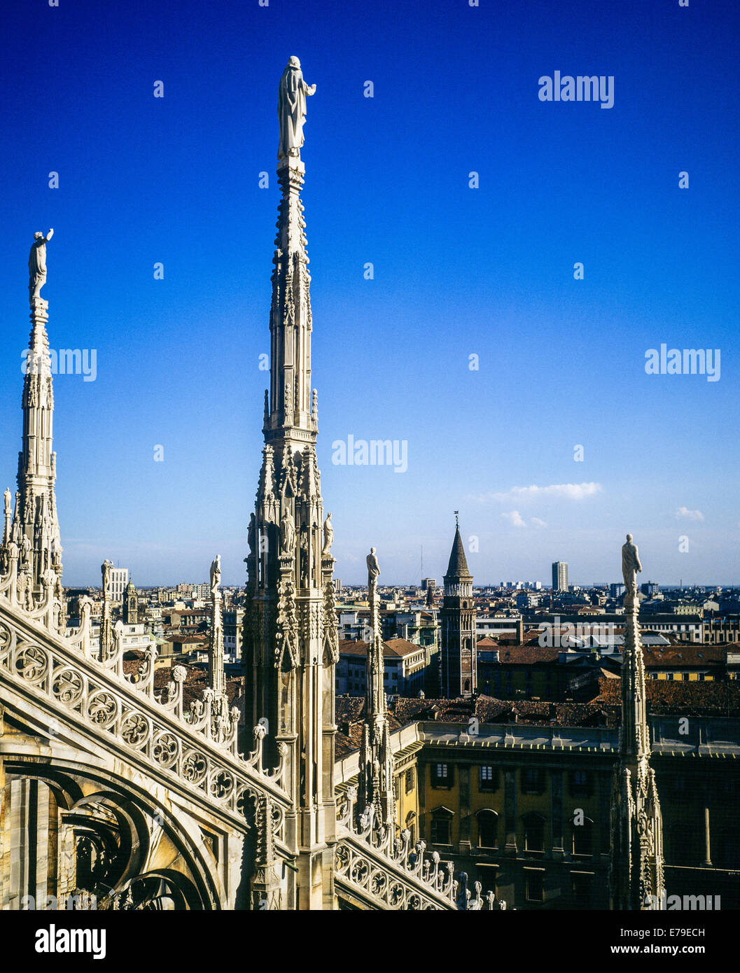 Spire statues of Duomo cathedral and town skyline Milan Lombardy Italy ...