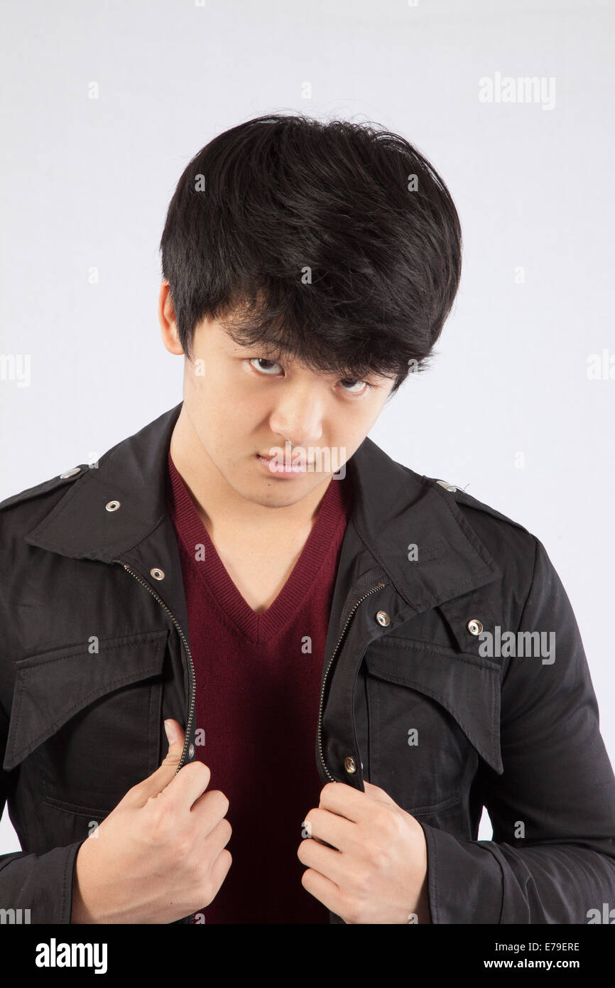 Handsome East Asian man wearing a jacket and with a thoughtful ...