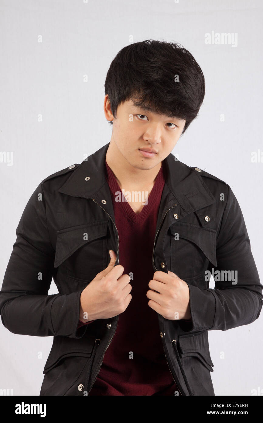 Handsome East Asian man wearing a jacket and with a thoughtful ...