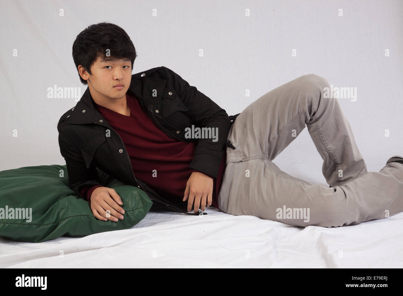 Handsome East Asian man wearing a jacket and with a thoughtful ...