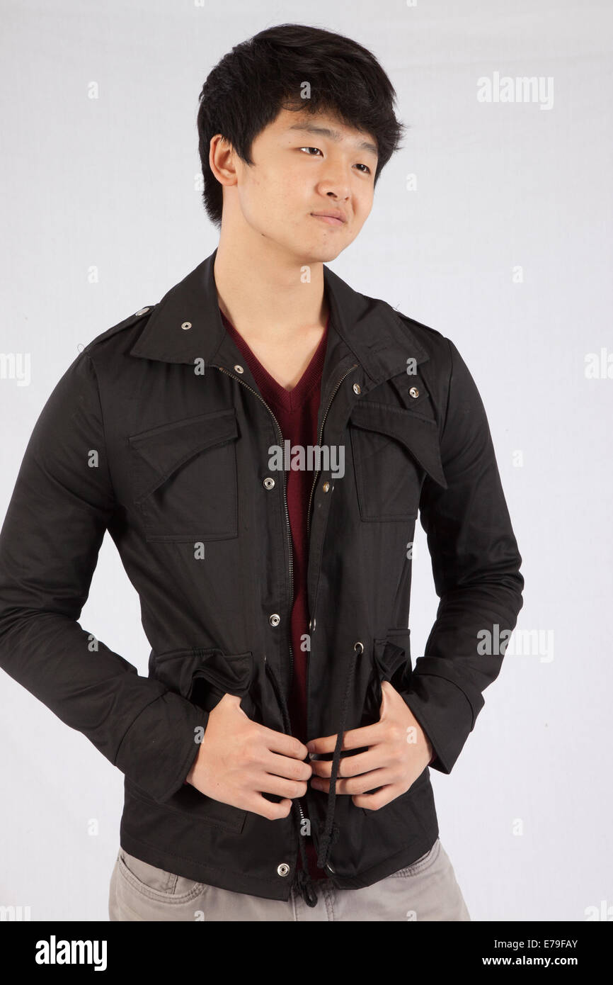 Handsome East Asian man wearing a jacket and with a thoughtful ...