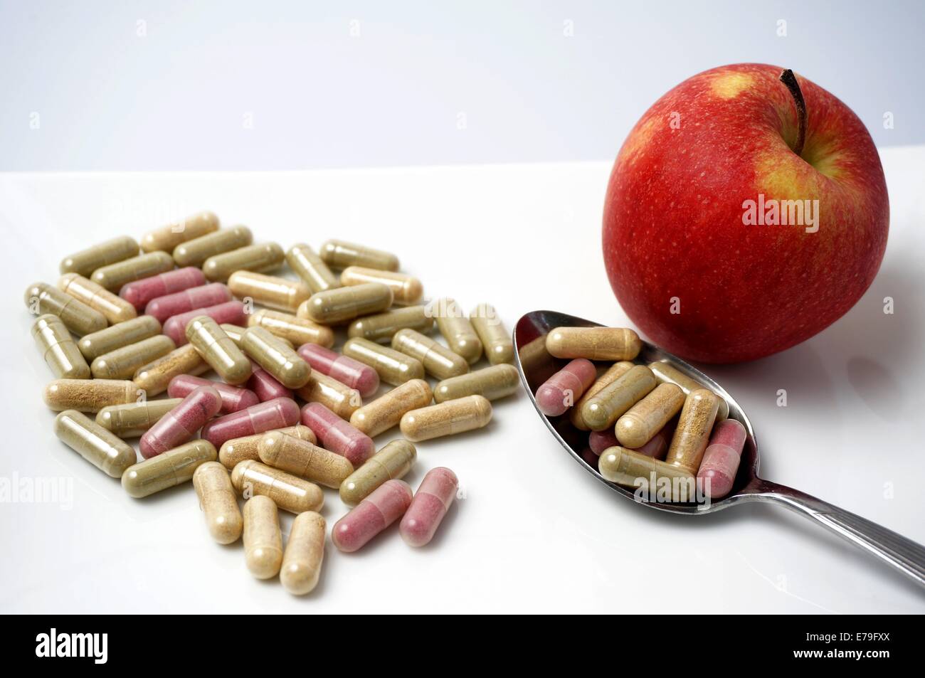 many Medicine capsule vs one healthy apple Stock Photo - Alamy