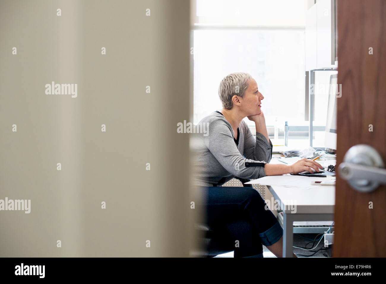 A woman working in an office alone. Focusing on a task, using a ...