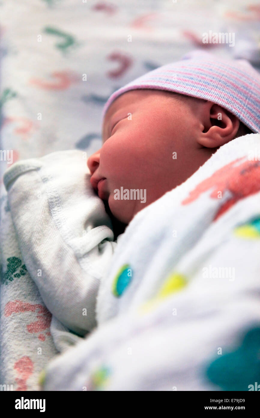 Sleeping newborn baby in hospital. The first hours of life of the ...