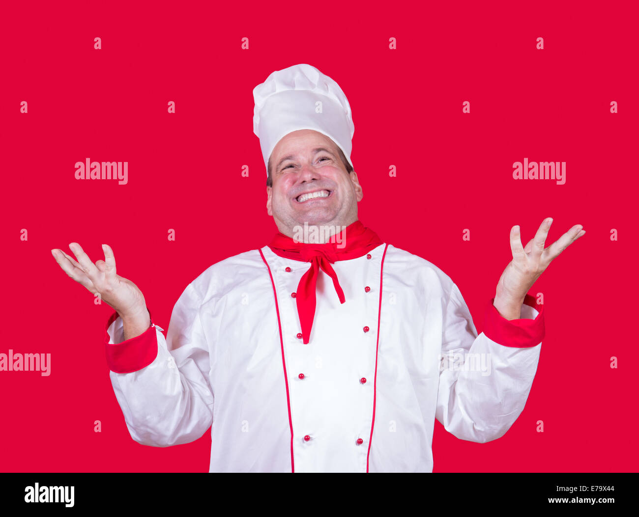 cheerful cook on a red background Stock Photo - Alamy