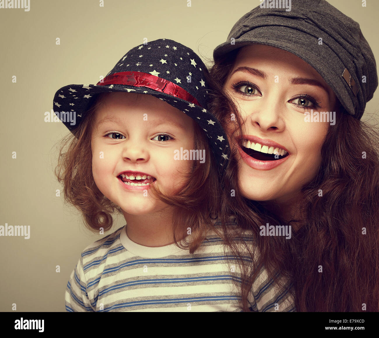 Fashion mother and kid girl happy toothy laughing in trendy caps ...