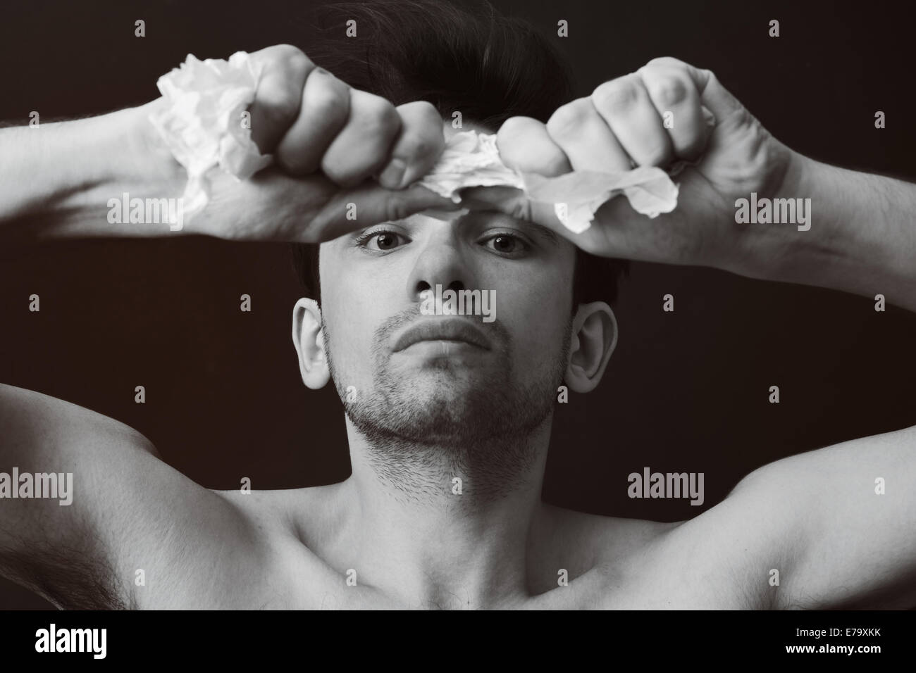 Portrait of a young man tearing paper Stock Photo - Alamy