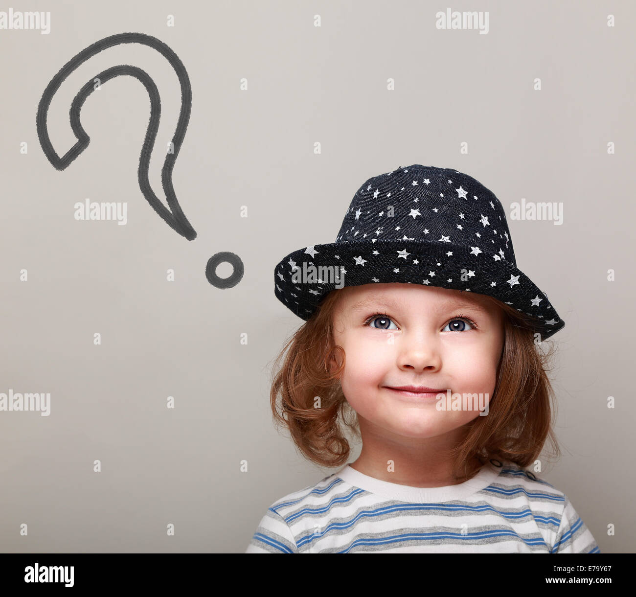 Thinking cute kid with big question sign above looking up on grey ...