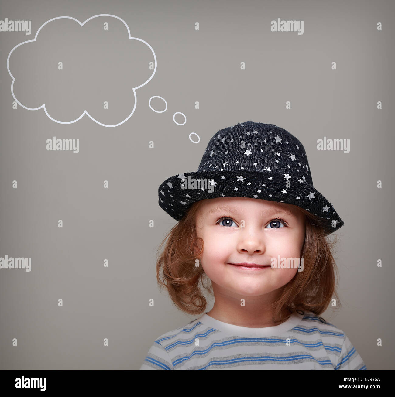 Thinking kid girl looking up on empty bubble above on grey background ...