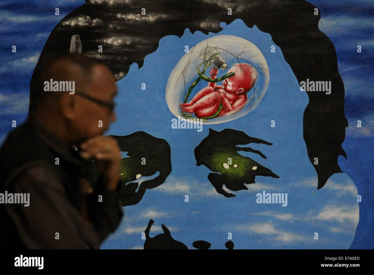 Visitor observes paintings by Munir, an Indonesian artists, during an ...
