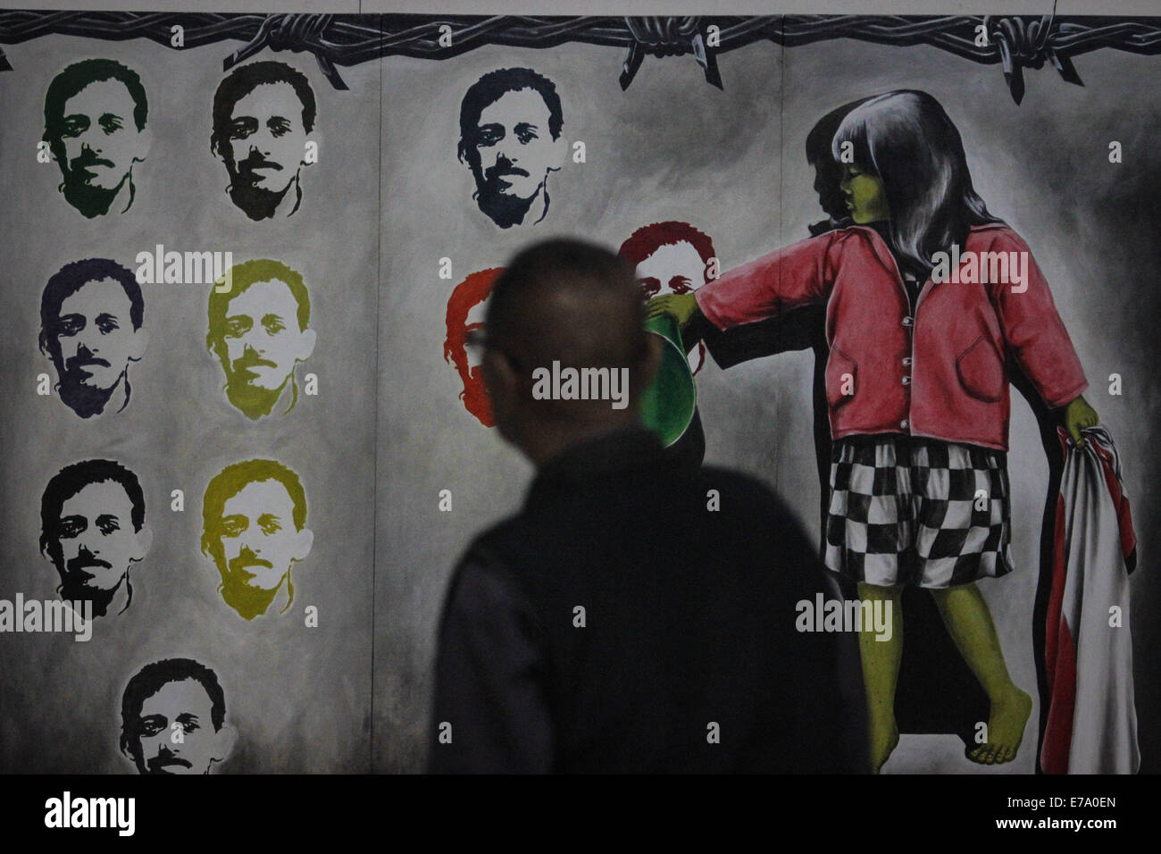 A visitor views paintings by Munir, an Indonesian artists, during an ...