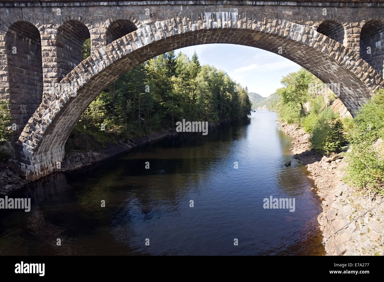 old big stone bridge over straight blue river Stock Photo - Alamy