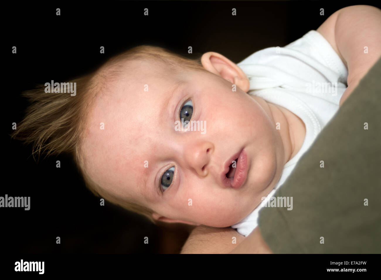 An almost four month old baby looking neutral on black background Stock ...