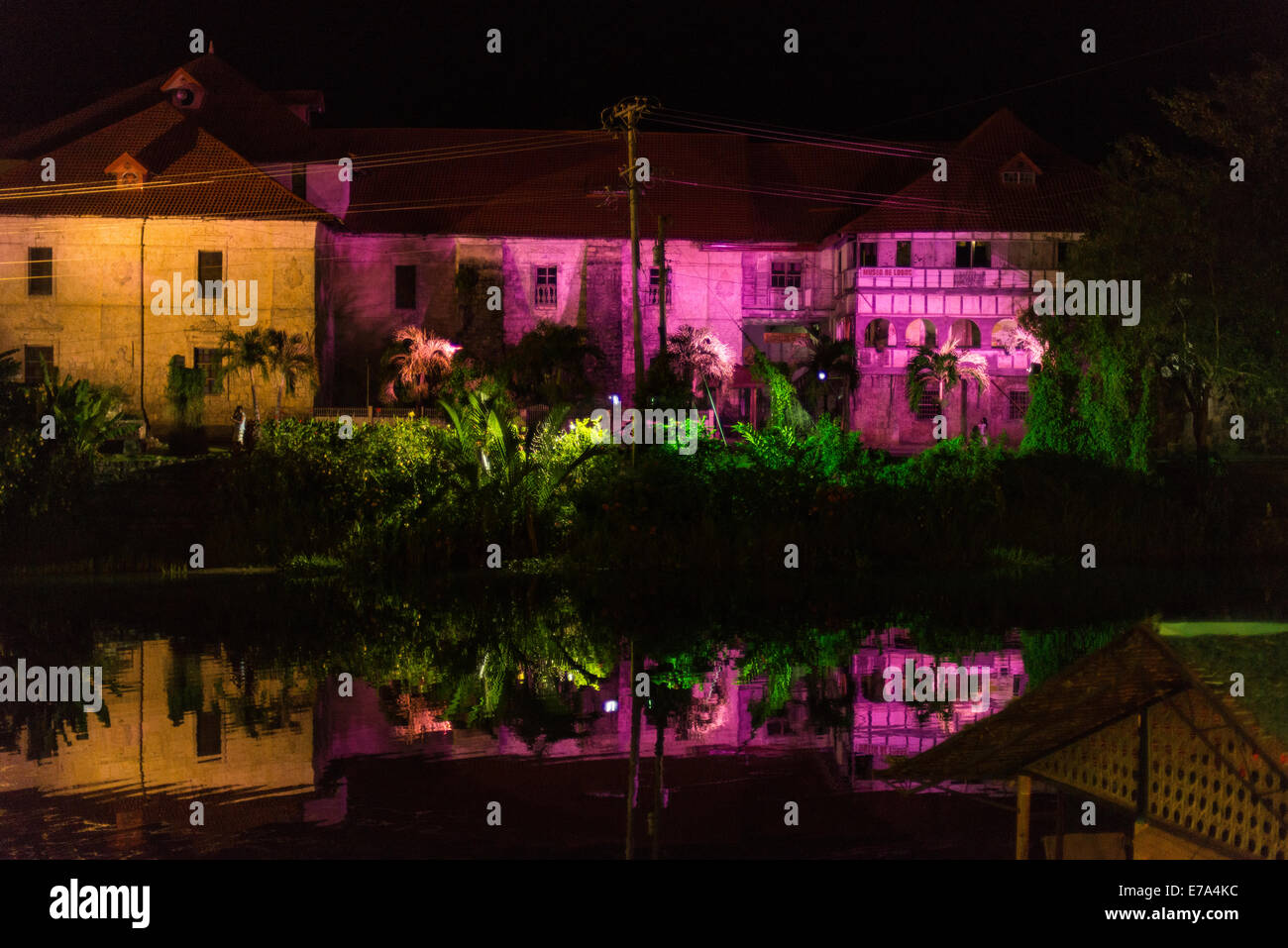 Side of Loboc Church colorfully lit and casting a reflection in Loboc ...