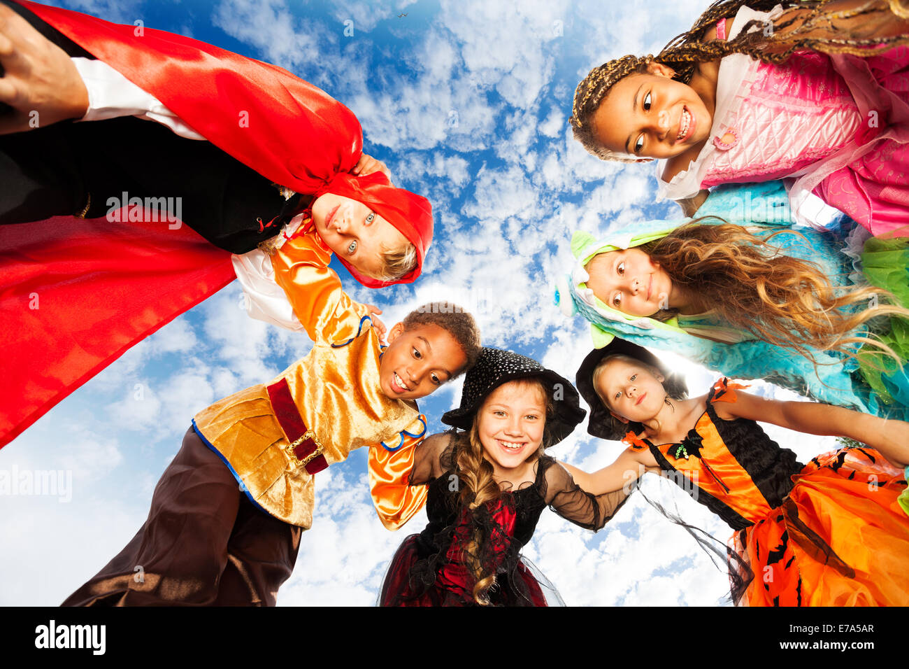 Group of kids wear Halloween costumes in circle Stock Photo - Alamy