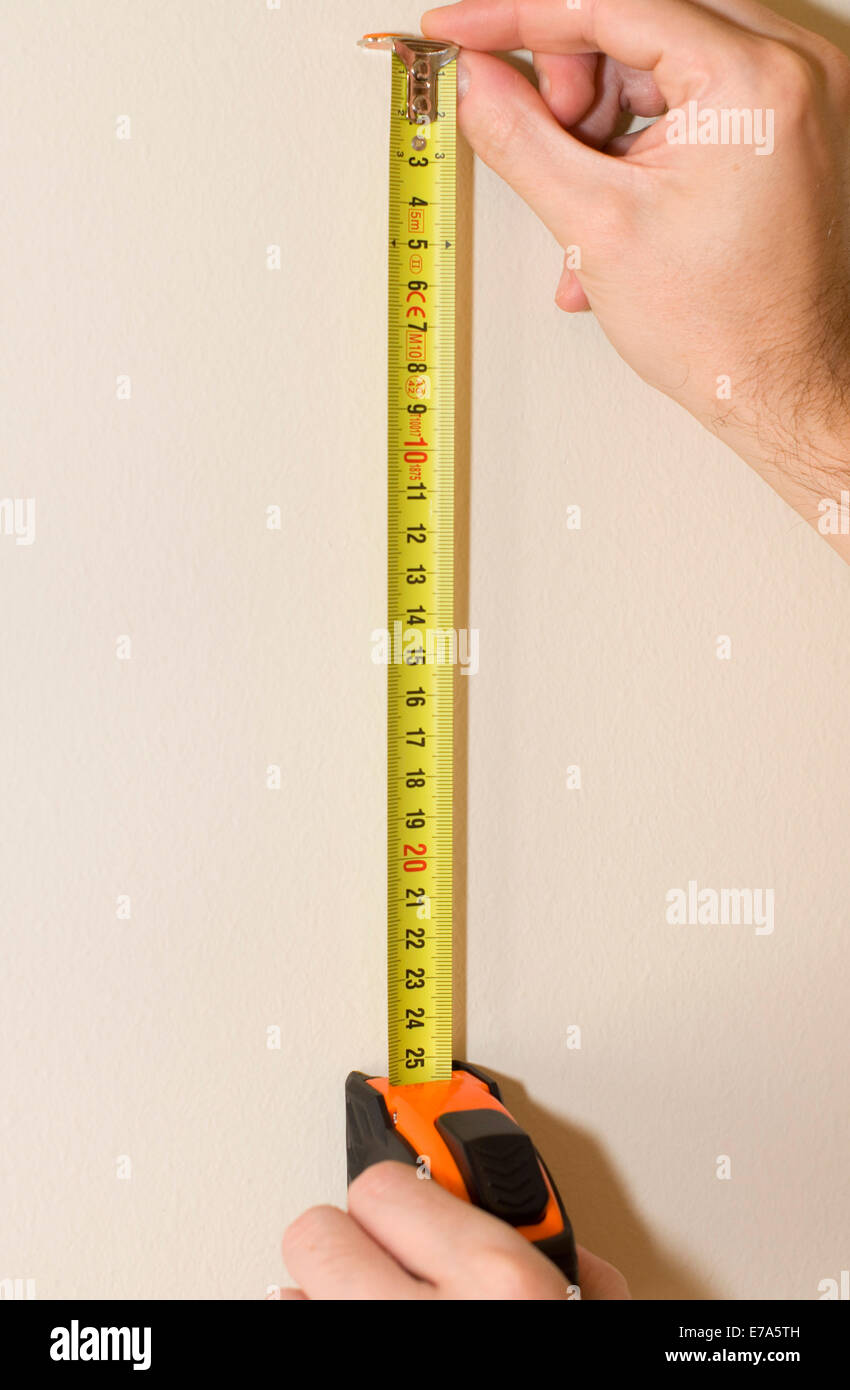 Hands of a man taking measures in a wall Stock Photo - Alamy