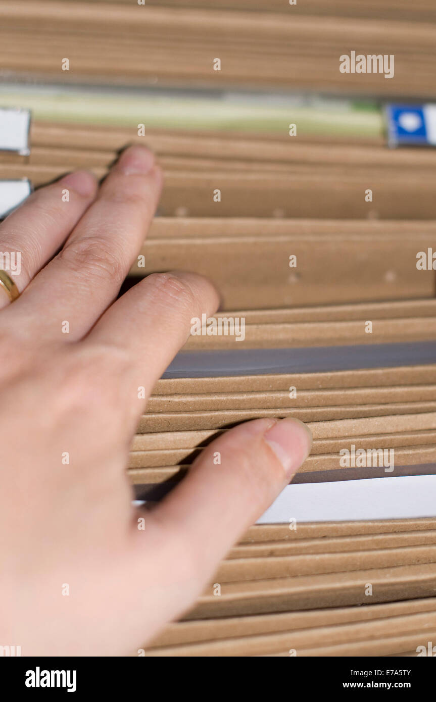 A hand of someone searching a document in a file cabinet Stock Photo ...