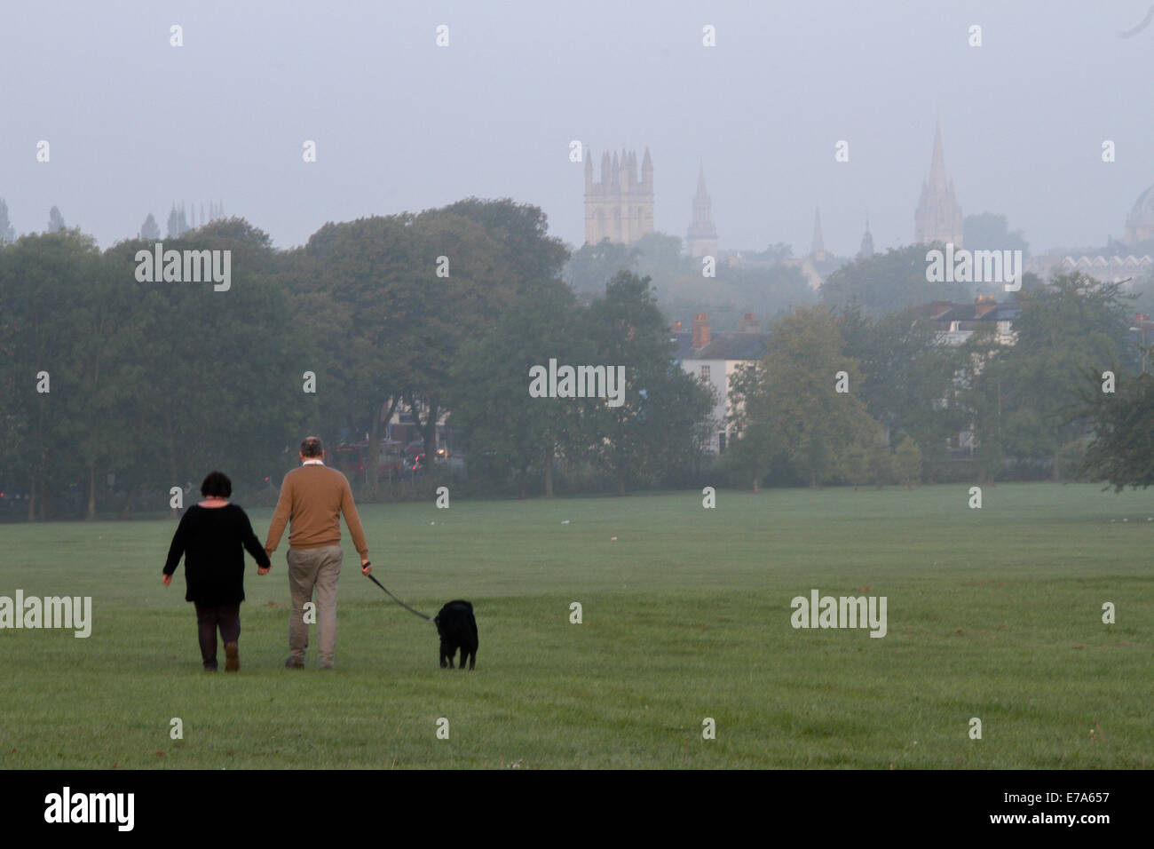 Oxford, UK. 11th September 2014. A couple walks their dog in south park ...