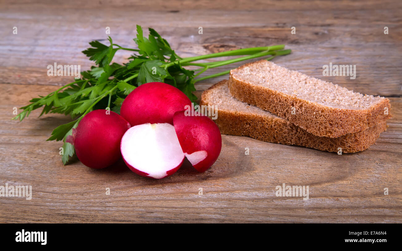 Fresh red radish parsley and bread on old wooden surface Stock Photo ...