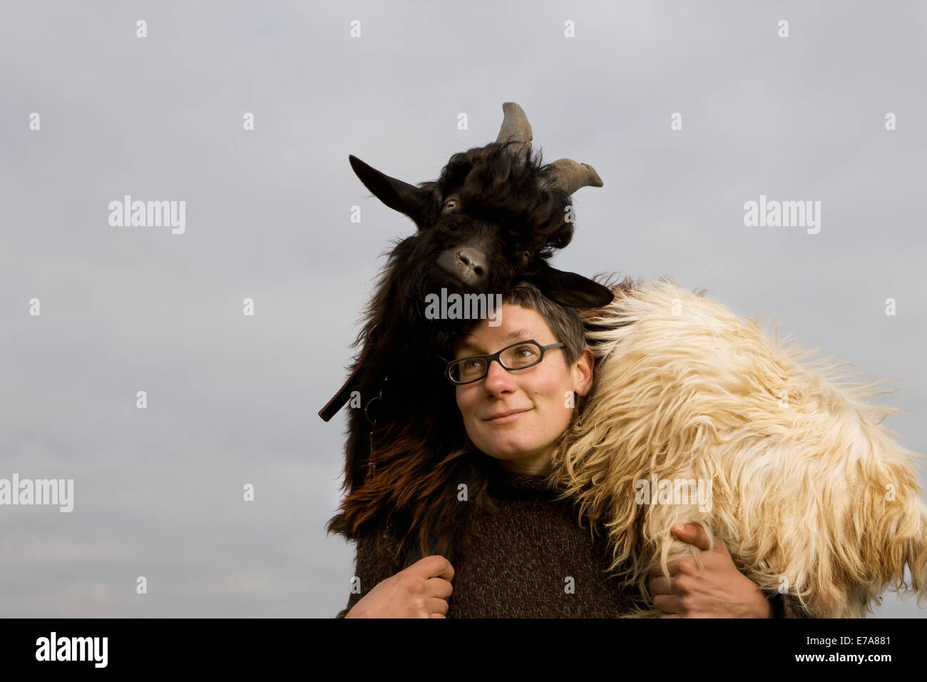Woman carrying goat on shoulder Stock Photo - Alamy