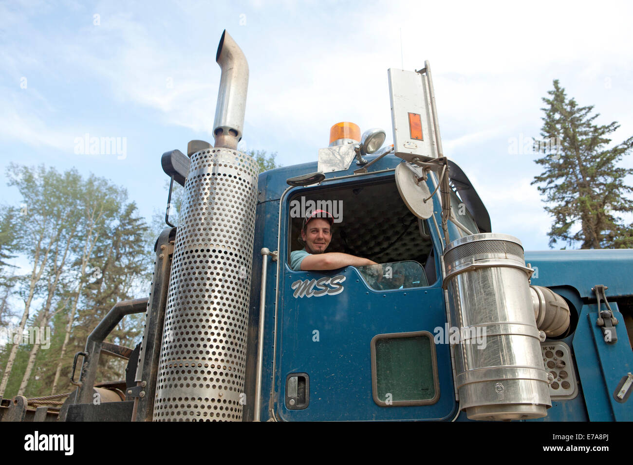 Portrait of haulage truck driver looking out of driver cab window, low ...