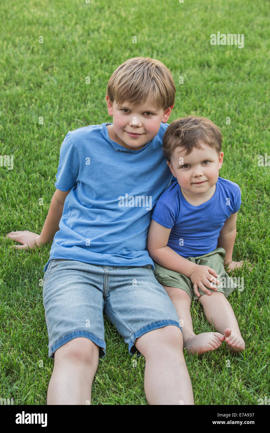 Portrait of brothers relaxing in park Stock Photo - Alamy
