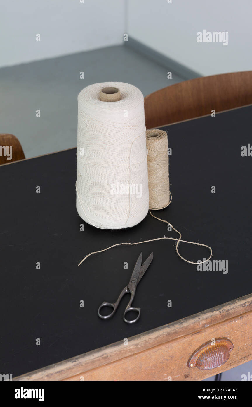 Thread spools and scissors on table at home Stock Photo - Alamy