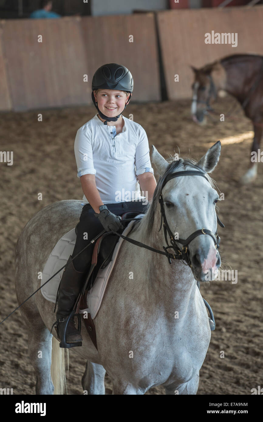Young boy riding horse in training stable Stock Photo - Alamy