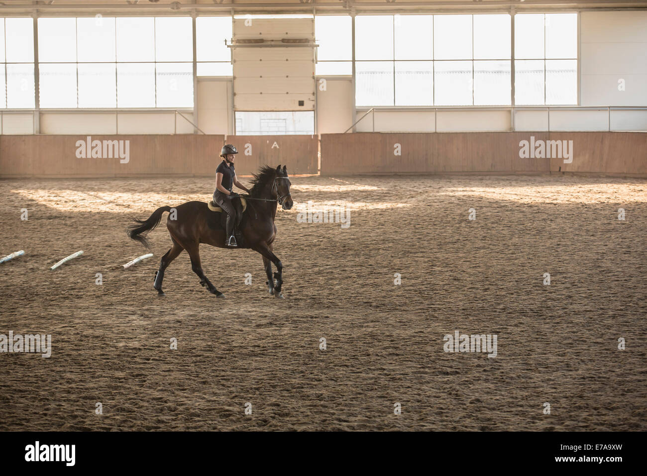 Woman riding horse in training stable Stock Photo - Alamy