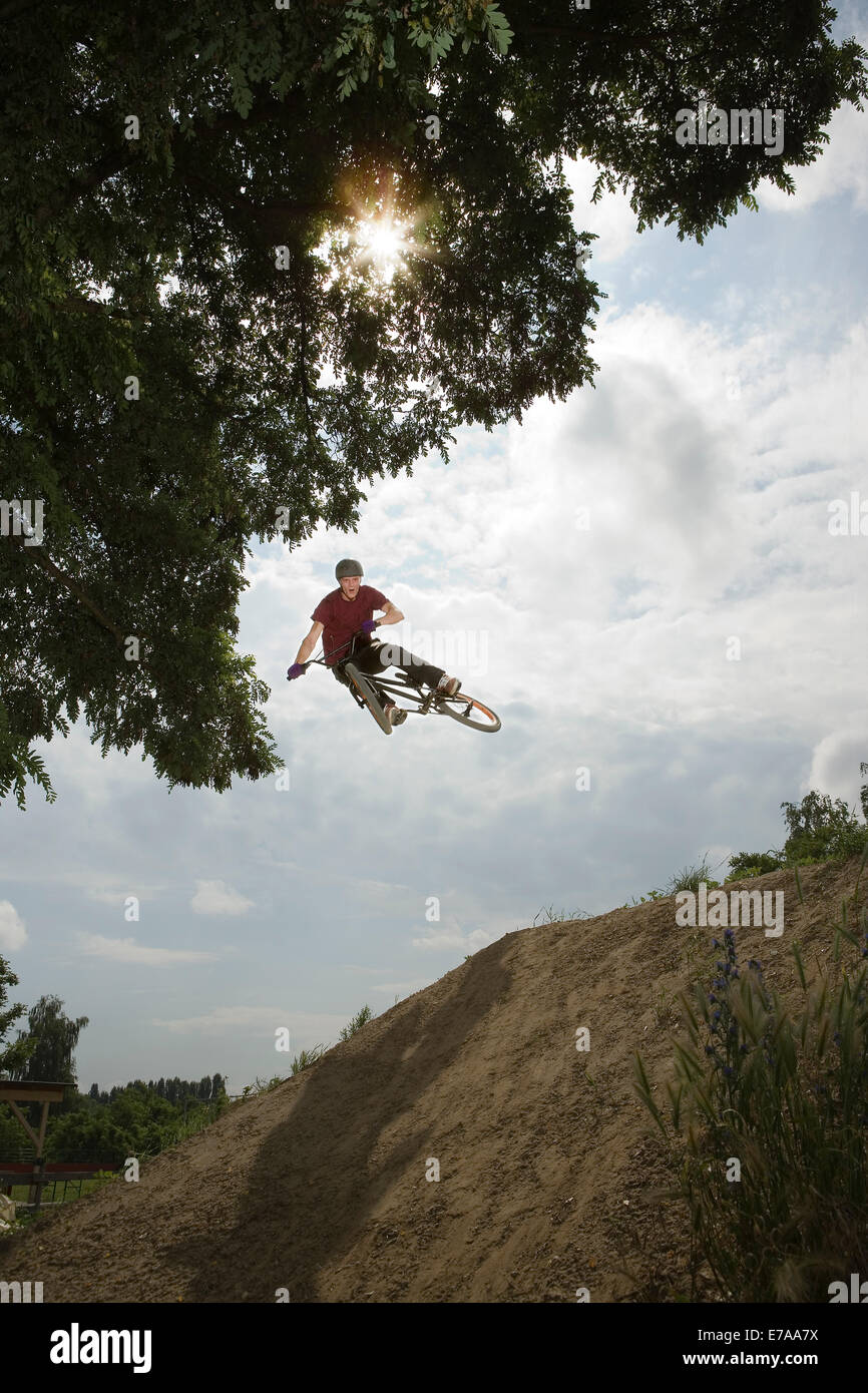 A BMX rider in mid-air at the top of a mud slope Stock Photo - Alamy