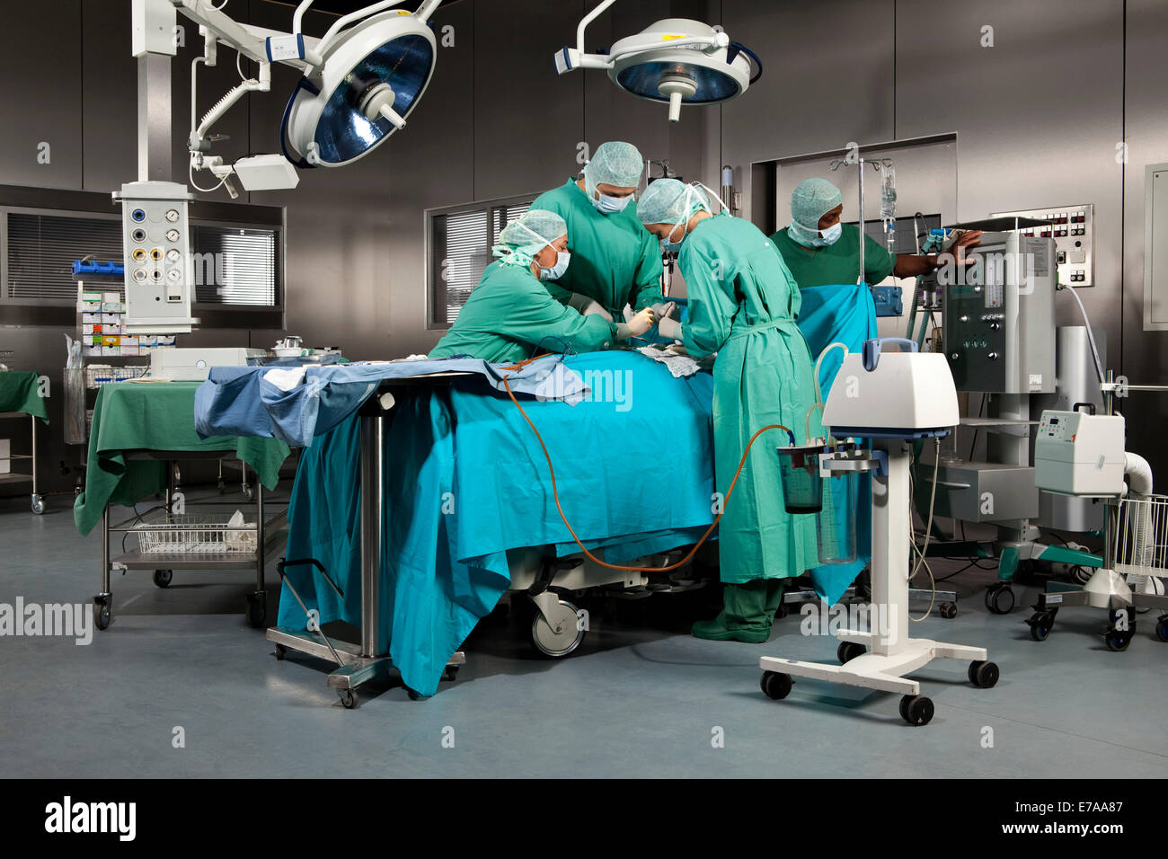 Doctors and nurses operating on a patient in a operating room Stock ...