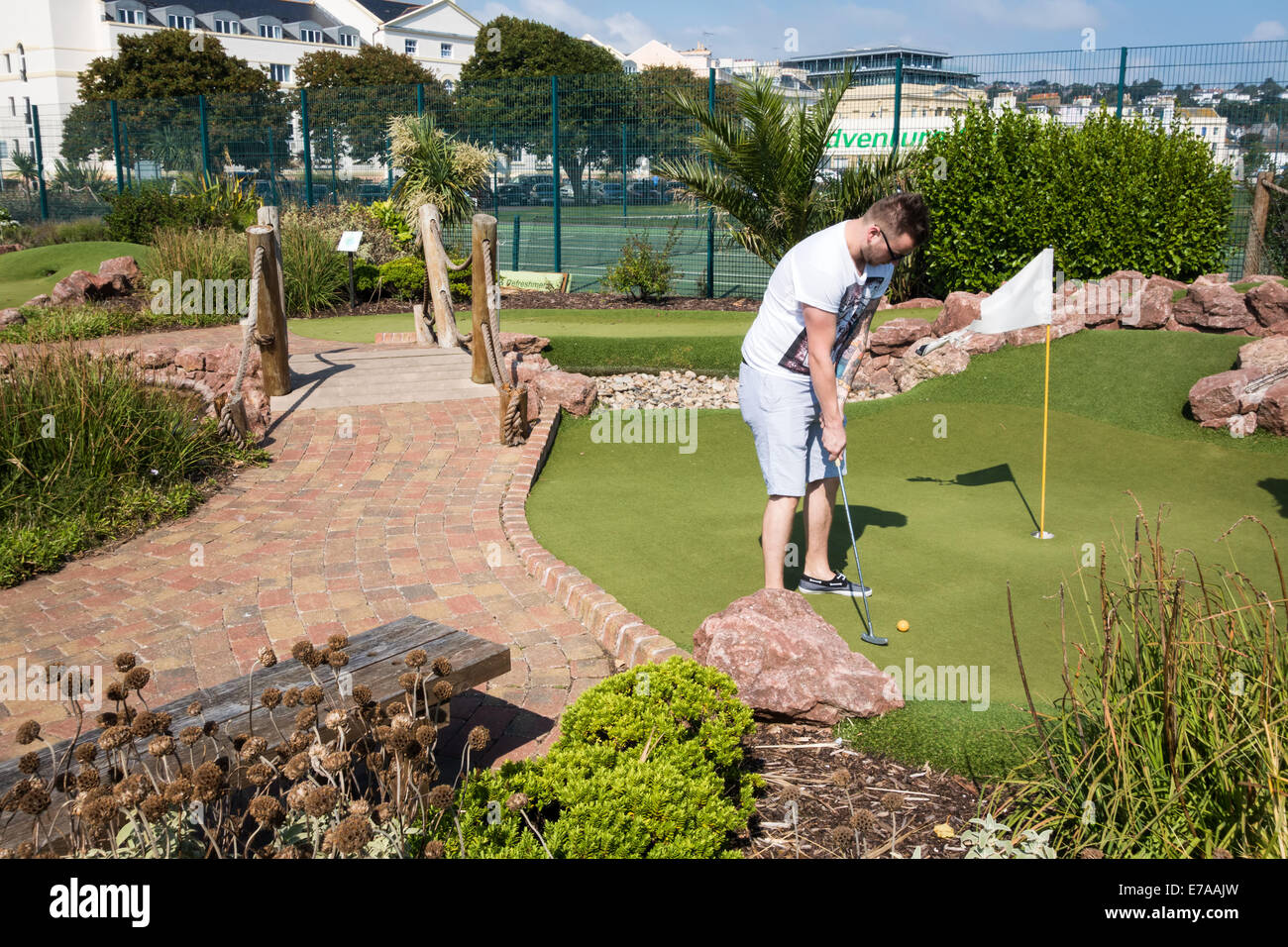 The Crazy Golf obstacle course on Teignmouth sea front. A young man in ...