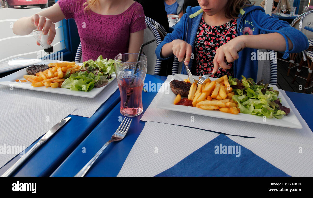 Two children eating steak hache with frites Stock Photo - Alamy