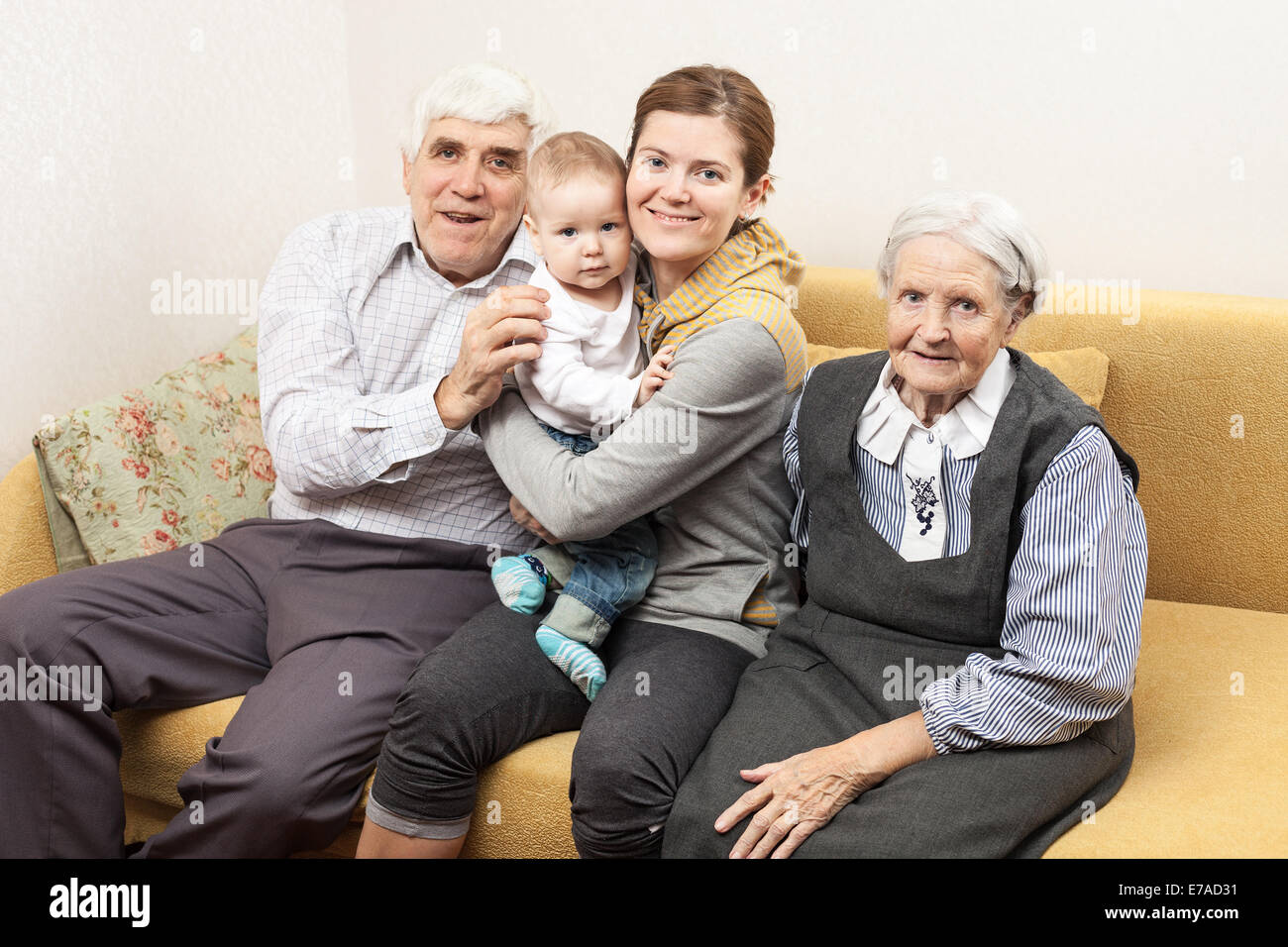 Four generation family sitting on sofa at home Stock Photo - Alamy