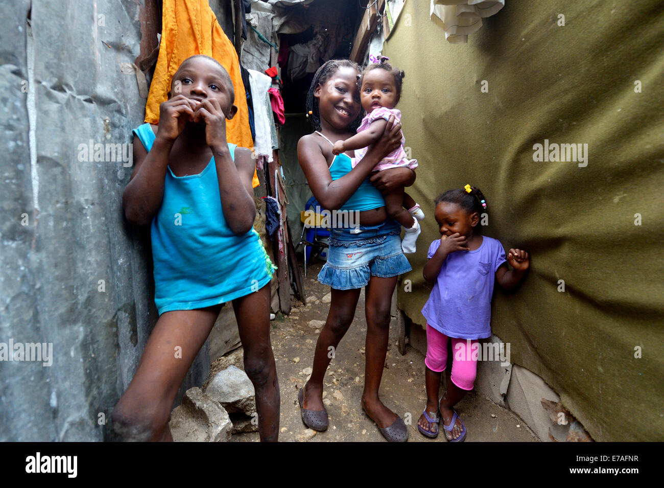 Four children in the entrance of a shack, Camp Icare for earthquake ...