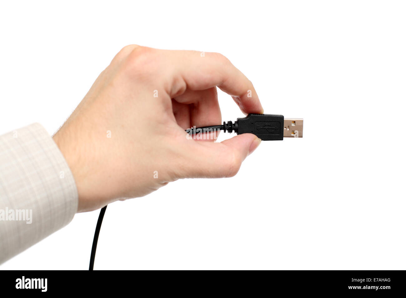 Hand holding USB cable against white background. Shallow depth of field ...