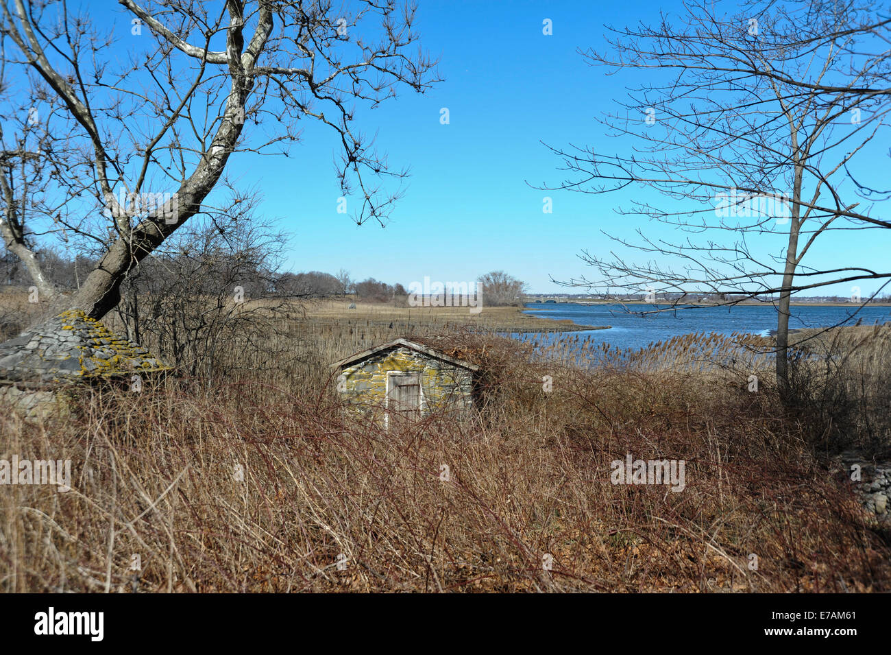 Winter view of blue water pond with old stone buildings in foreground ...