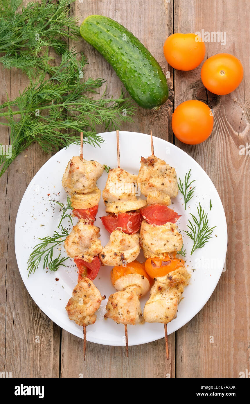 Chicken shish kebab and fresh vegetables on rustic wooden table, top ...