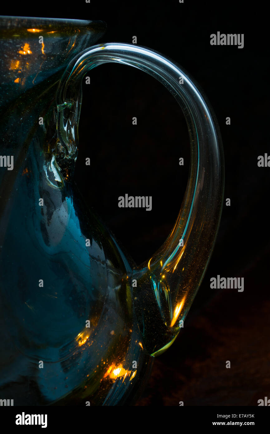 A blown glass tea pitcher, illuminated by candlelight Stock Photo - Alamy
