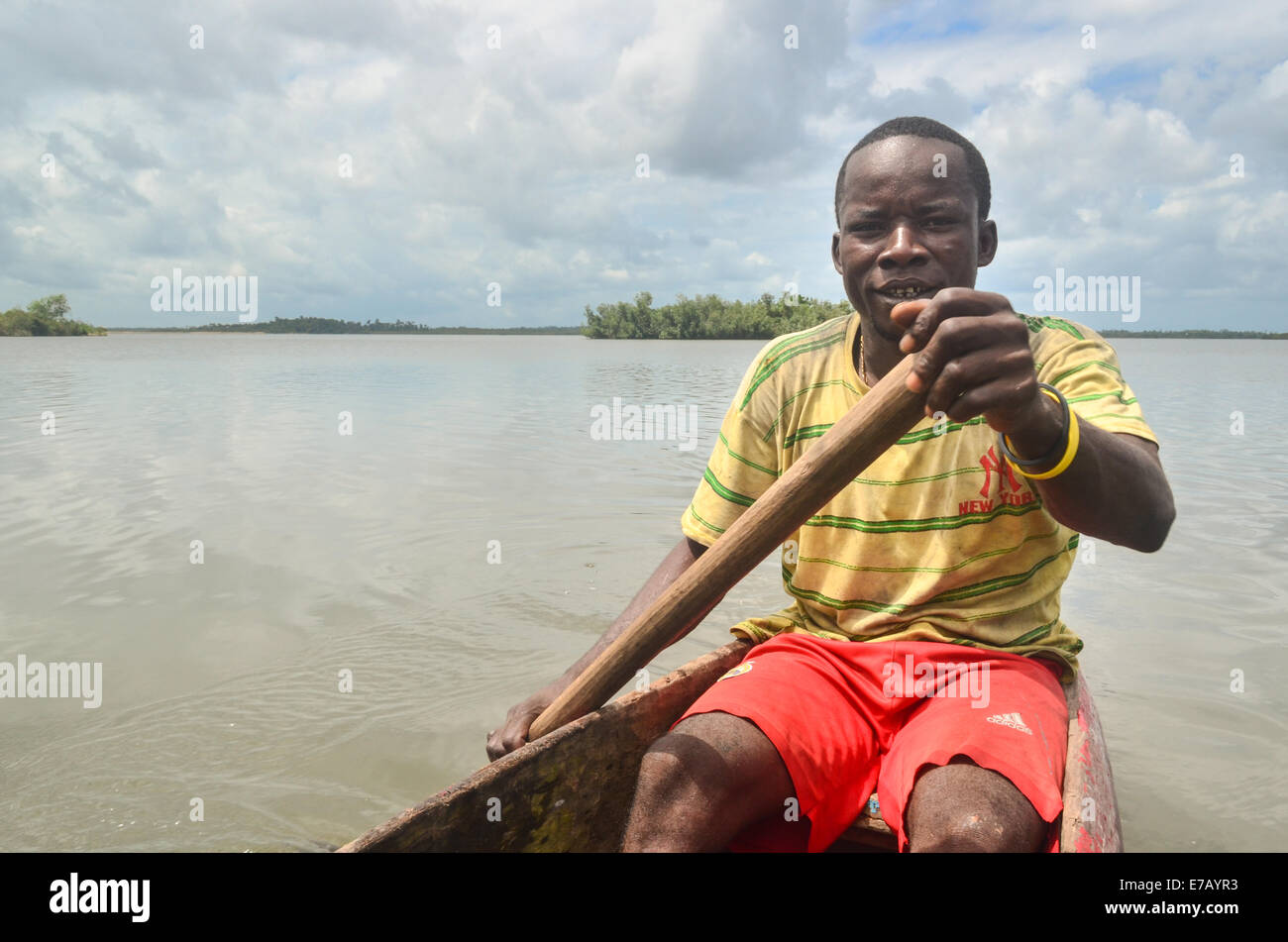 A canoe sailor crossing the lagoon of Lake Piso during the rainy season ...